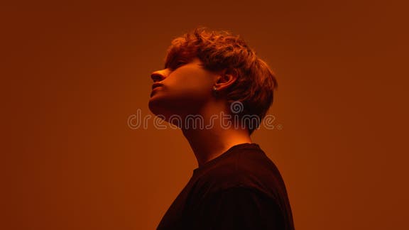 Side View of Young Man with Tilted Head with Expression Unreadable in ...