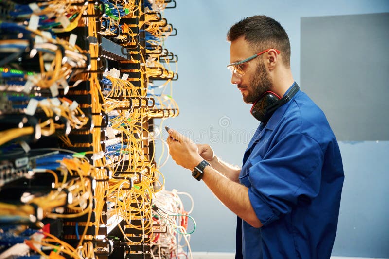 Side View. Young Man is Working with Internet Equipment and Wires in ...