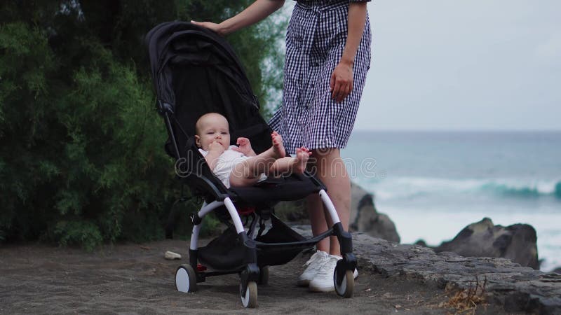 Side View of Young Mother Pushing Baby Stroller Over Summer Beach ...