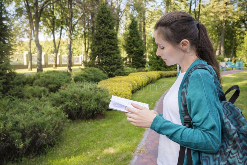 Side View of a Young Woman Reading a Book in the Park Stock Photo ...