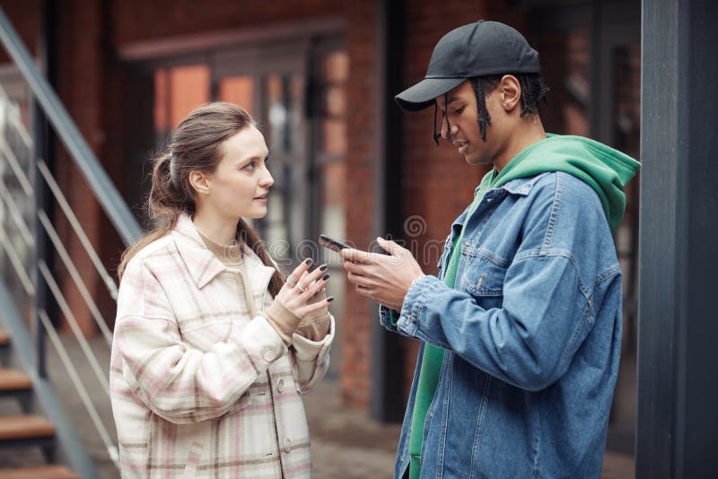 Side View Of Youthful Couple In Casualwear Having Chat While Guy