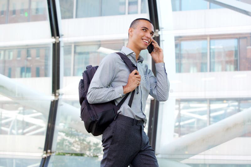 Side of Young Businessman Walking and Talking on Cellphone Stock Photo ...