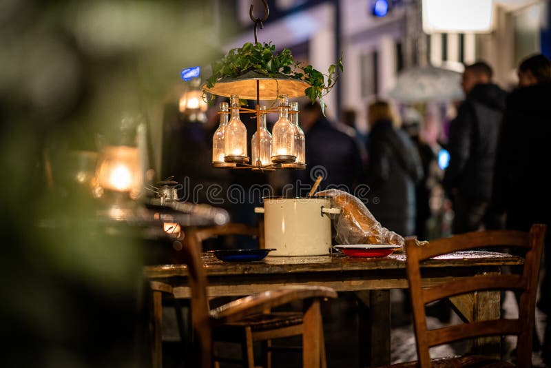 Sidewalk Eatery with Wooden Chairs and Tables and Rustic Chandelier ...