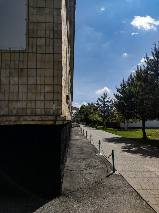 A Sidewalk Next To a Building with a Chain Link Fence Stock Photo ...