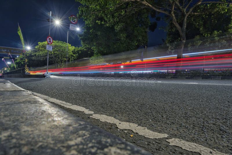 Sidewalk at Night with Light Trails of Passing Vehicles Stock Photo ...