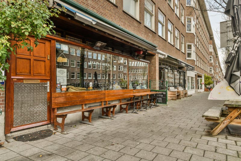 A Sidewalk Outside of a Restaurant with Benches and Tables Editorial ...