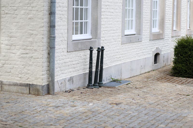 Sidewalk Posts Against a White Building Stock Image - Image of posts ...