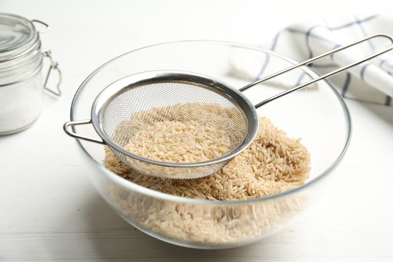 Sieve with Rice in Bowl on White Wooden Table Stock Image - Image of ...