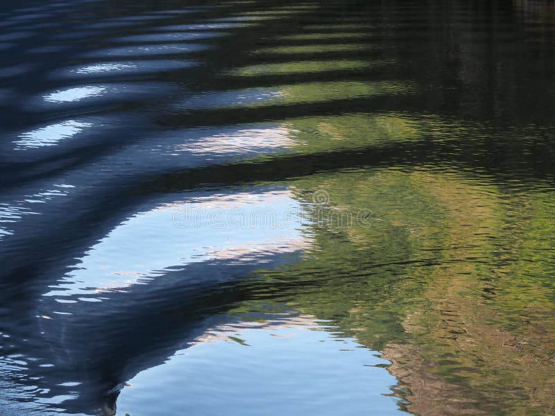 A Sightseeing Ship Wake Creates Multi-colored Patterns in the Water of ...