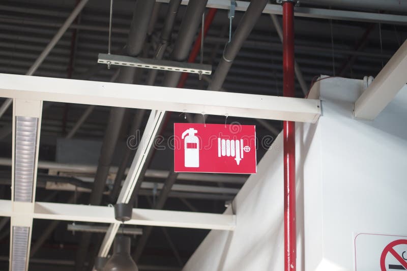 Sign Hanging from Ceiling Showing Fire Extinguisher and Hose Symbols ...