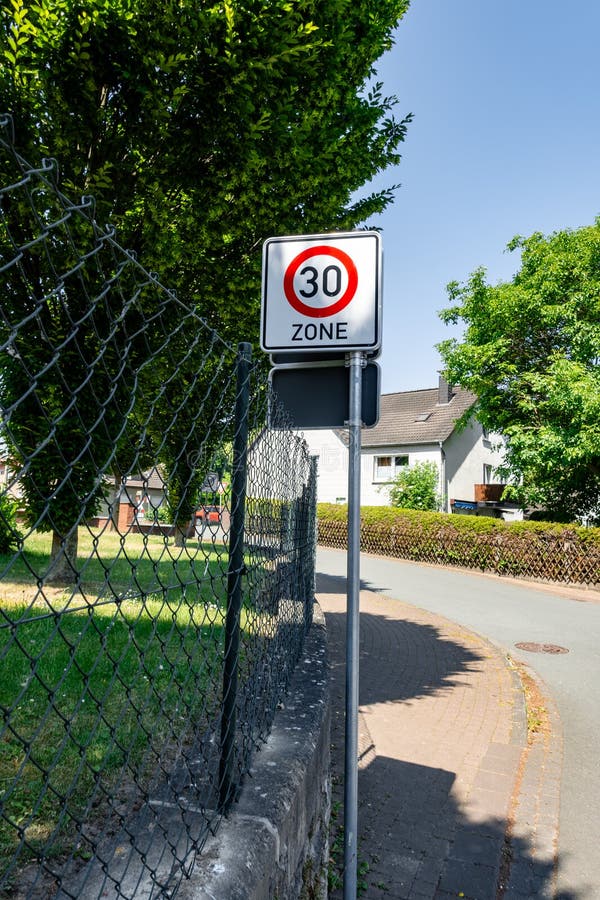 A Sign with a Red Circle and White Number 30 on it is Posted on a Pole ...