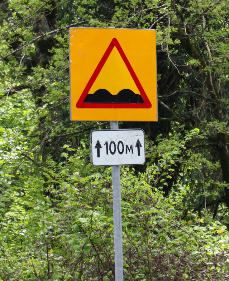 A Sign with a Red Triangle and Yellow Border Warns of a Steep Drop ...