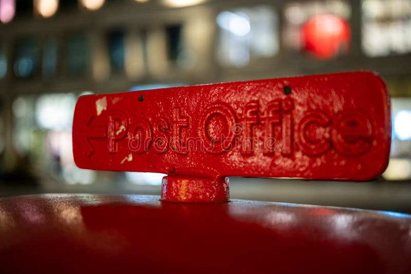 A Sign on Top of a Traditional British Red Post Box Pointing Towards a ...