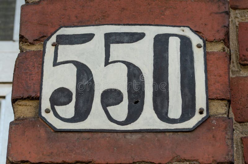 A Sign on a Wall with the Number Five Hundred Fifty Stock Photo - Image ...