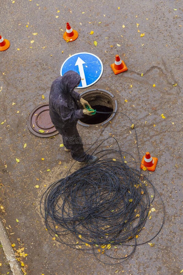 Signalman Worker Pulling an Electric Cable through the City Well Stock ...