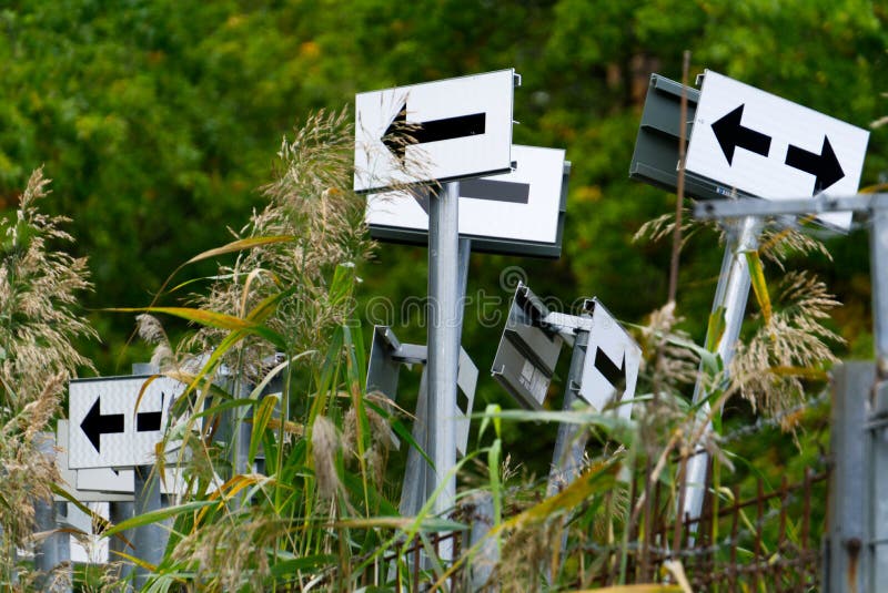 Signs with Arrows Behind a Rusty Fence by the Forest Stock Photo ...
