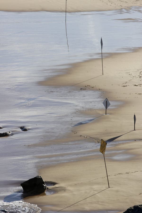 Signs Stuck in the Sand by the Beach, Vertical Stock Photo - Image of ...