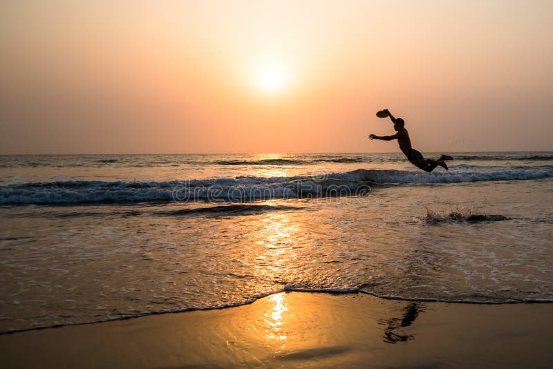 Silhouette of Active Man Playing Frisbee on Sunset Beach Editorial ...