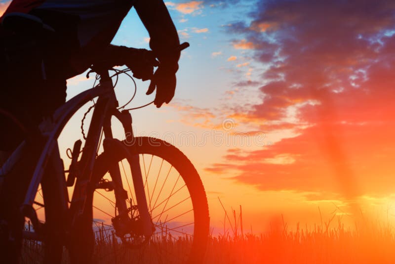 Silhouette of a Biker and Bicycle on Sunset Background. Stock Image ...