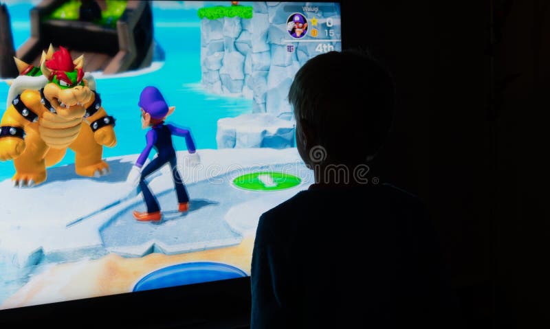 Silhouette of a Boy Standing in Front of a Large TV Screen Watching the ...