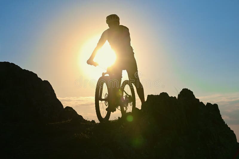 Silhouette of a Cyclist Standing on Clif Against the Sun Stock Photo ...