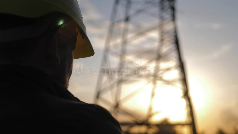 Engineer Standing on Field with Electricity Towers. Electrical Engineer ...