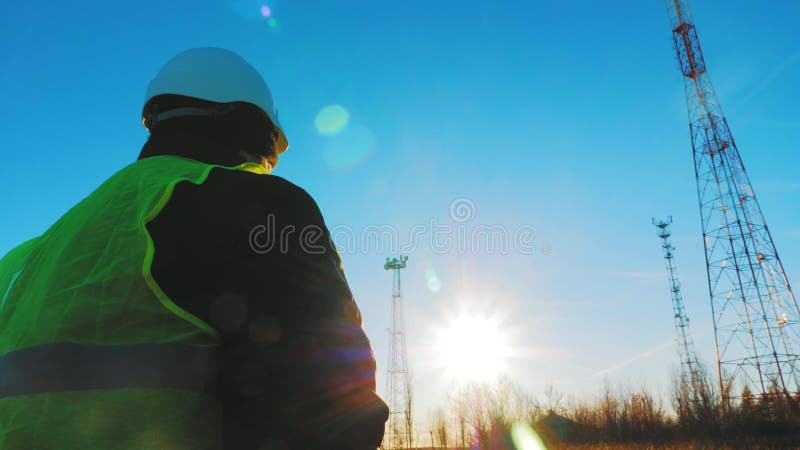 Silhouette of Engineer Standing on Field with Electricity Towers ...