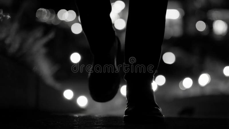 Silhouette of Feet Walking at Night with Lights Creates Moody ...
