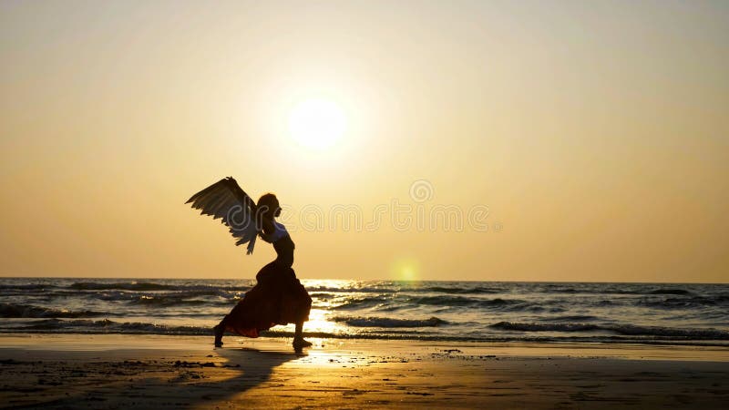 Silhouette of Female Angel on the Beach at Sunset Stock Photo - Image ...