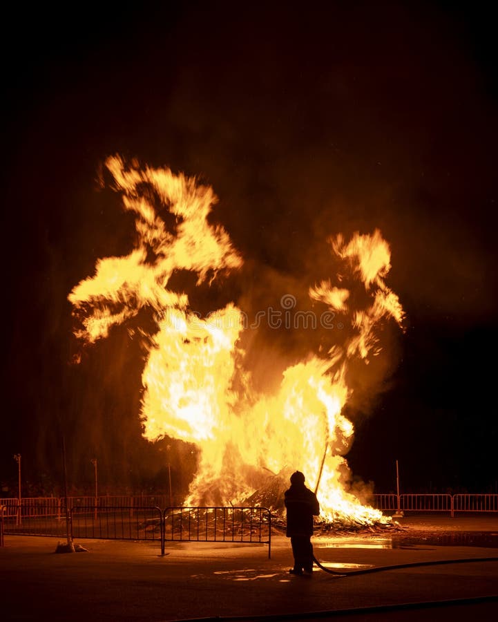 Silhouette of a Firefighter Standing before a Massive Bonfire Stock ...
