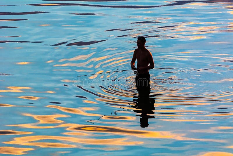 Silhouette of a Fisherman in Reflection in Water Ripples Stock Photo ...