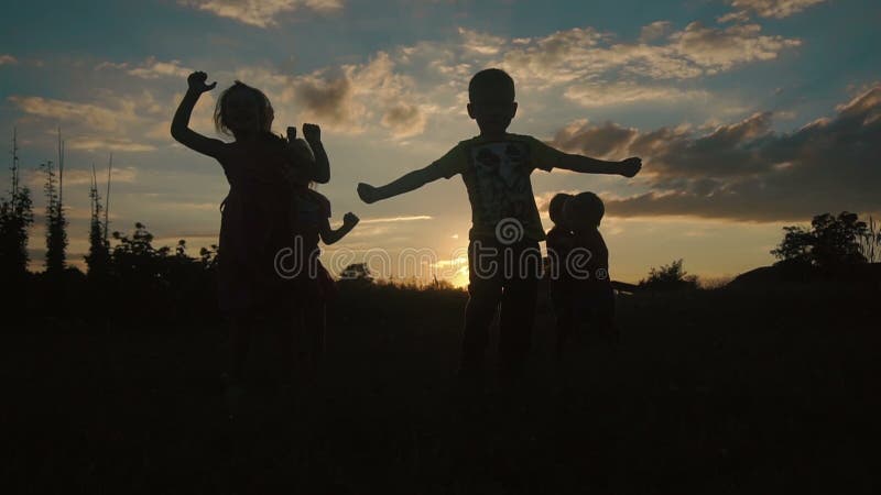The Silhouette of Five Little Children Having Fun and Dancing in the ...