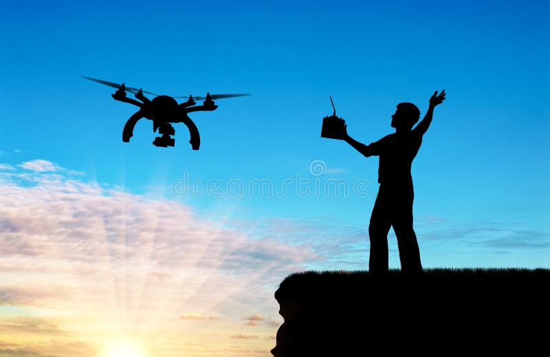 Silhouette of a Flying Drone, and a Man with a Remote Control on the ...