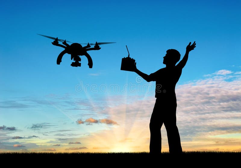 Silhouette of a Flying Drone, and a Man with a Remote Control at Sunset ...