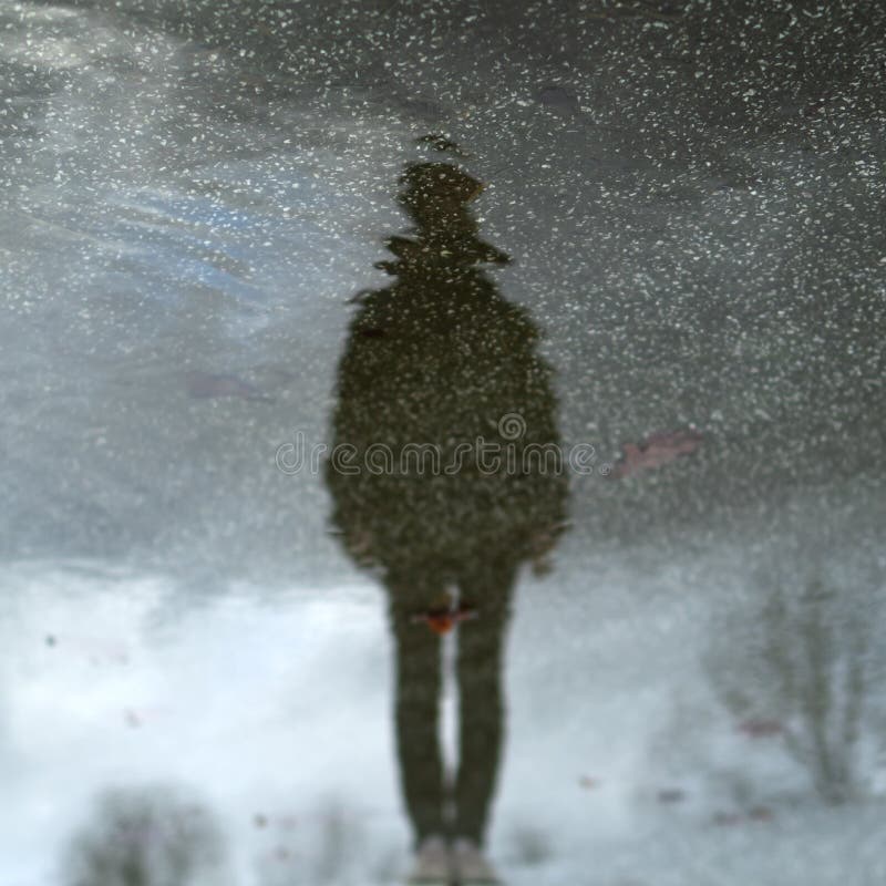 Silhouette in the puddle stock photo. Image of winter - 265440994