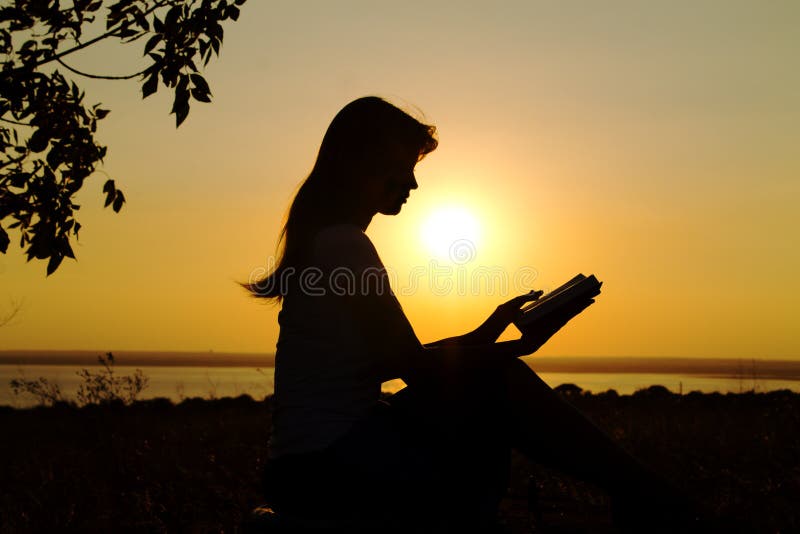 Silhouette of a Girl Reading at Sunset Stock Photo - Image of people ...