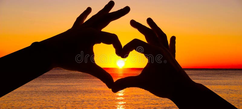 Silhouette Hand in Heart Shape and Sunrise Over the Ocean Stock Photo ...