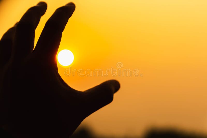 Silhouette of Hand is Holding the Orange Sun in Beautiful Sunset ...