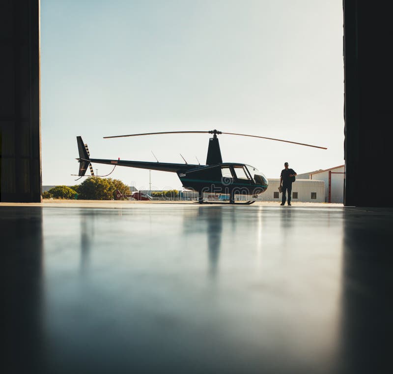 Silhouette of Helicopter and a Pilot in Hangar Stock Photo - Image of ...