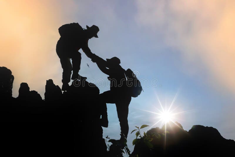 Silhouette of Hiker Helping Each Other Hike Up a Mountain at Sunset ...