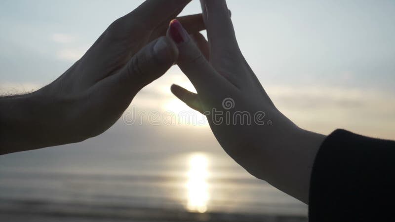 Silhouette of Holding Hands Making Heart Shape with Sunset Inside on ...