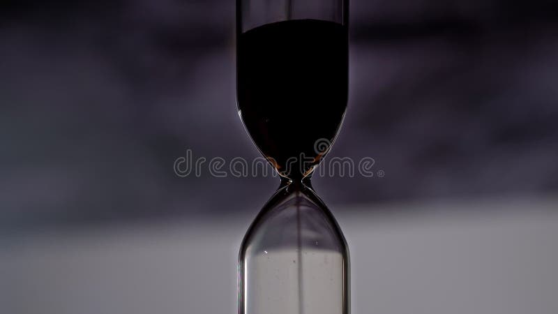Silhouette of Hourglass Flows Against Background of Ordinary Mechanical ...