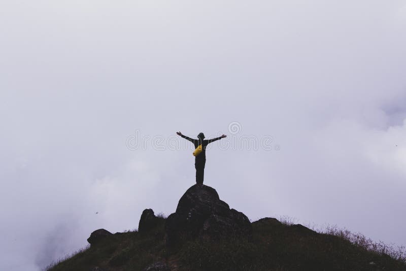 Silhouette Image of Man Standing with Arms Stretched on a Rock with ...