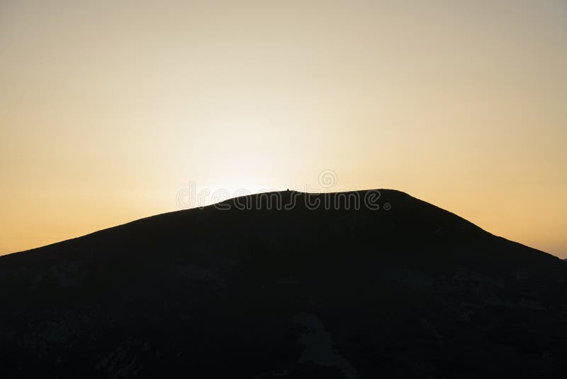 Silhouette of a Large Rocky Mountain in the Light of the Setting Sun ...