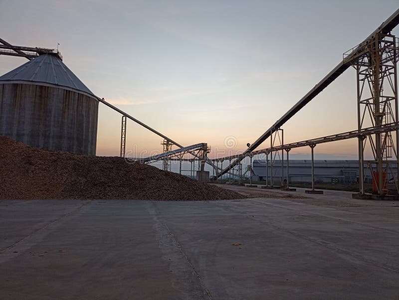 Silhouette Light Wood Chips Silo and Stack of Wood Yard Factory and ...