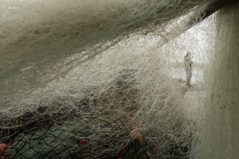 Silhouette of a Man through Fishing Nets Stock Photo - Image of ...