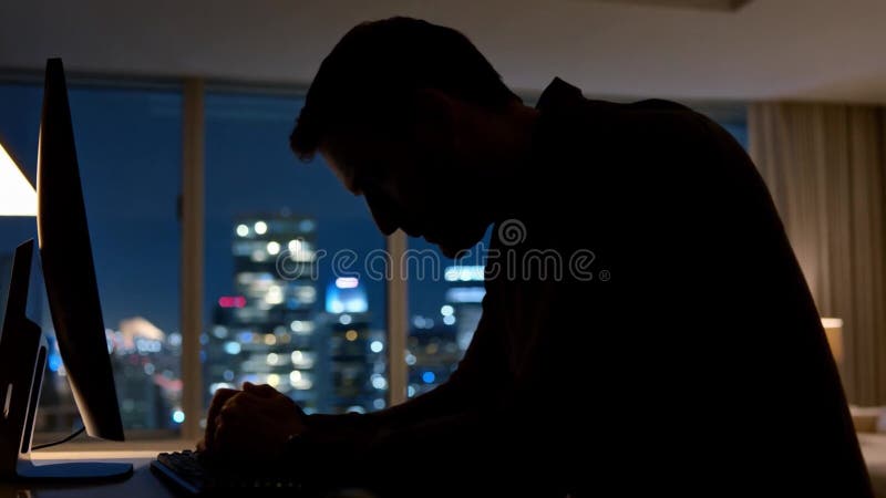 Silhouette of Man at Desk with Computer in High Rise Condominium ...