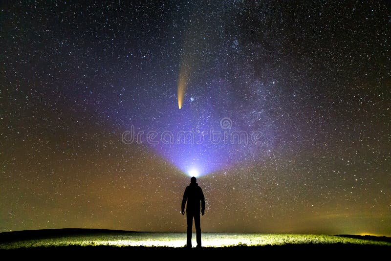Silhouette of a Man with Flashlight on His Head Pointing Bright Beam of ...