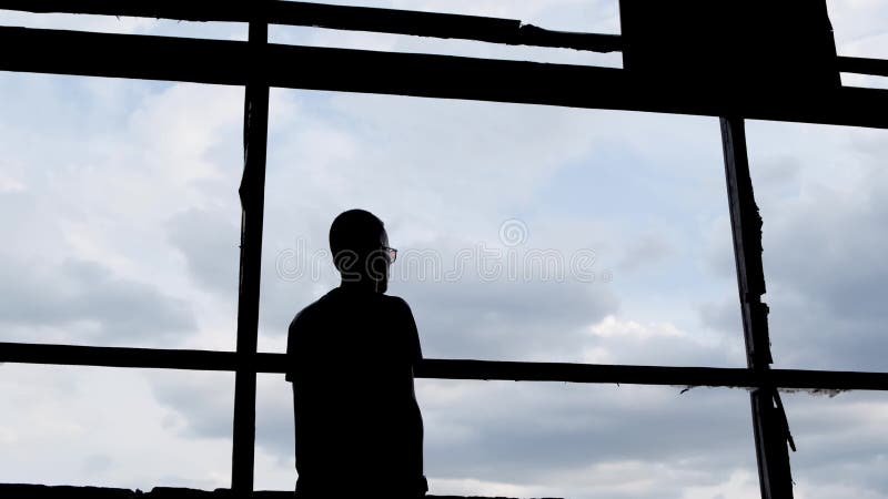 Silhouette of a Man in Front of a Large Broken Window. Consequences of ...