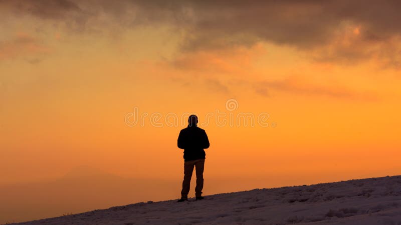 Silhouette of a Man on a Hill Staring at a Beautiful Sunset Stock Photo ...